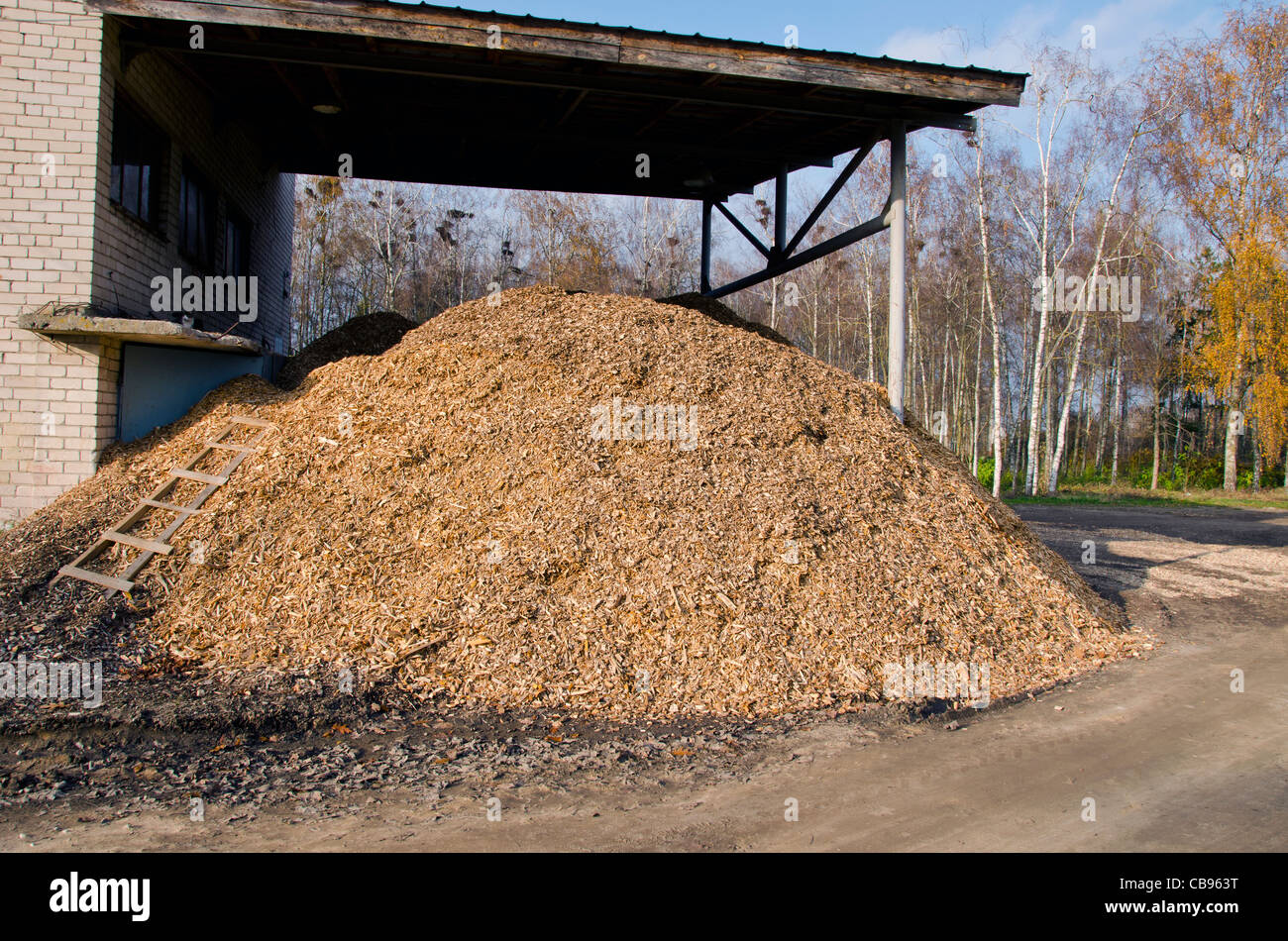 Stack of wood for burning near boiler. Biomass fuels. Chipped wood ...