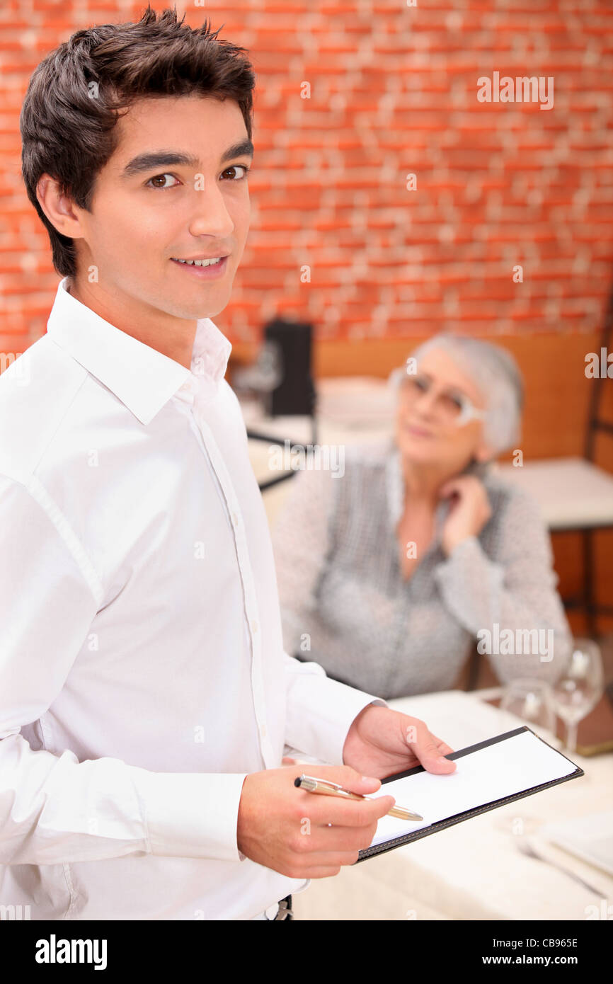 Young waiter taking an order in a restaurant Stock Photo - Alamy