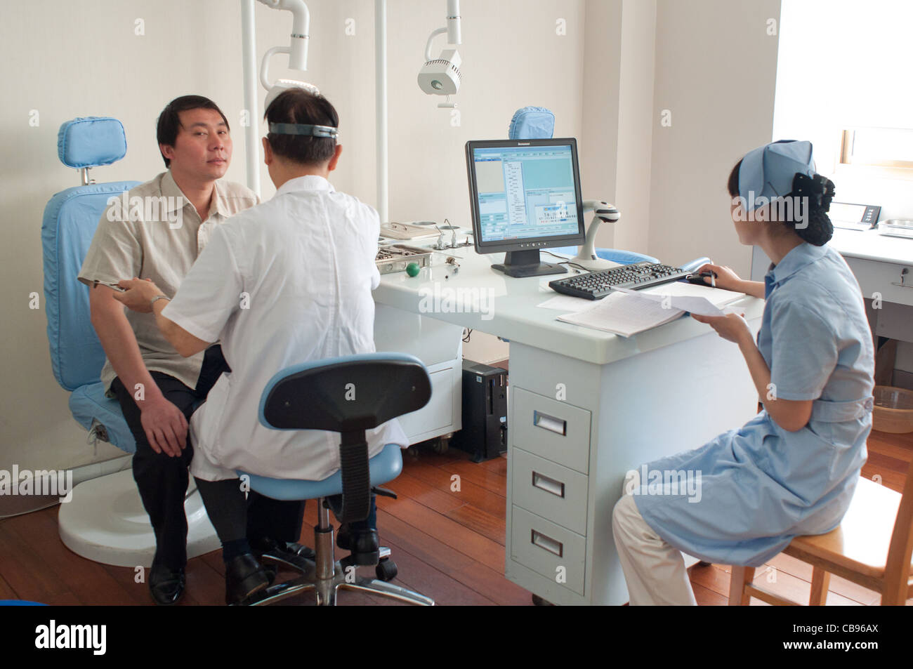A doctor visits a patient in a hospital, Huaxi Village, Jiangsu, China ...