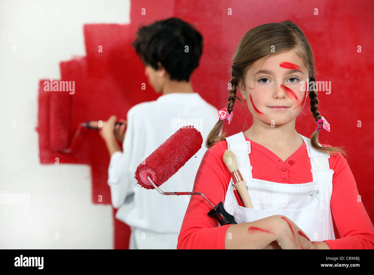 Children painting a wall red Stock Photo - Alamy