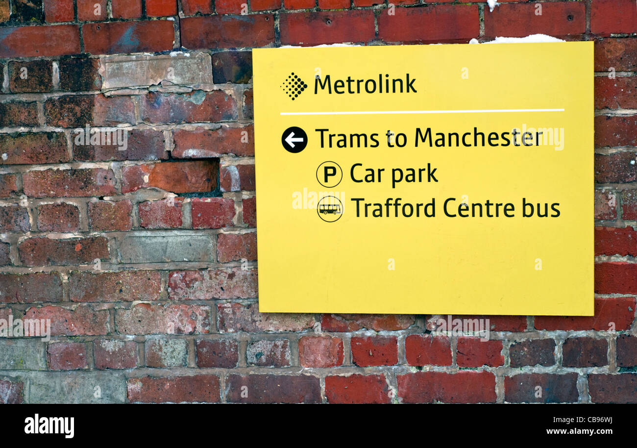 A yellow Metrolink sign on a brick wall at Stretford tram station in ...