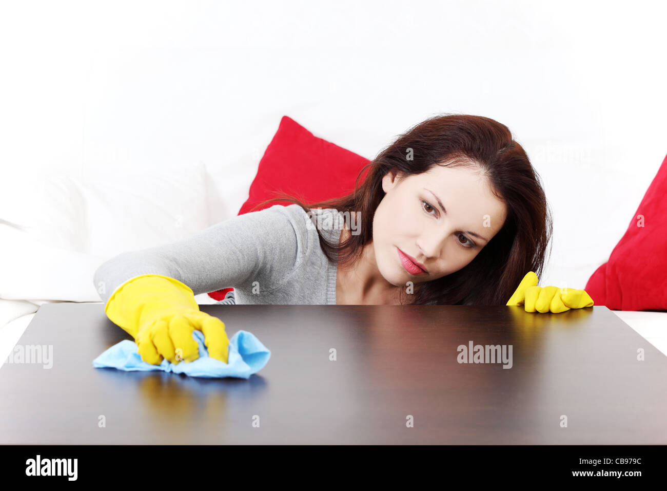 Front view of a young beautiful woman cleaning up the table at home ...