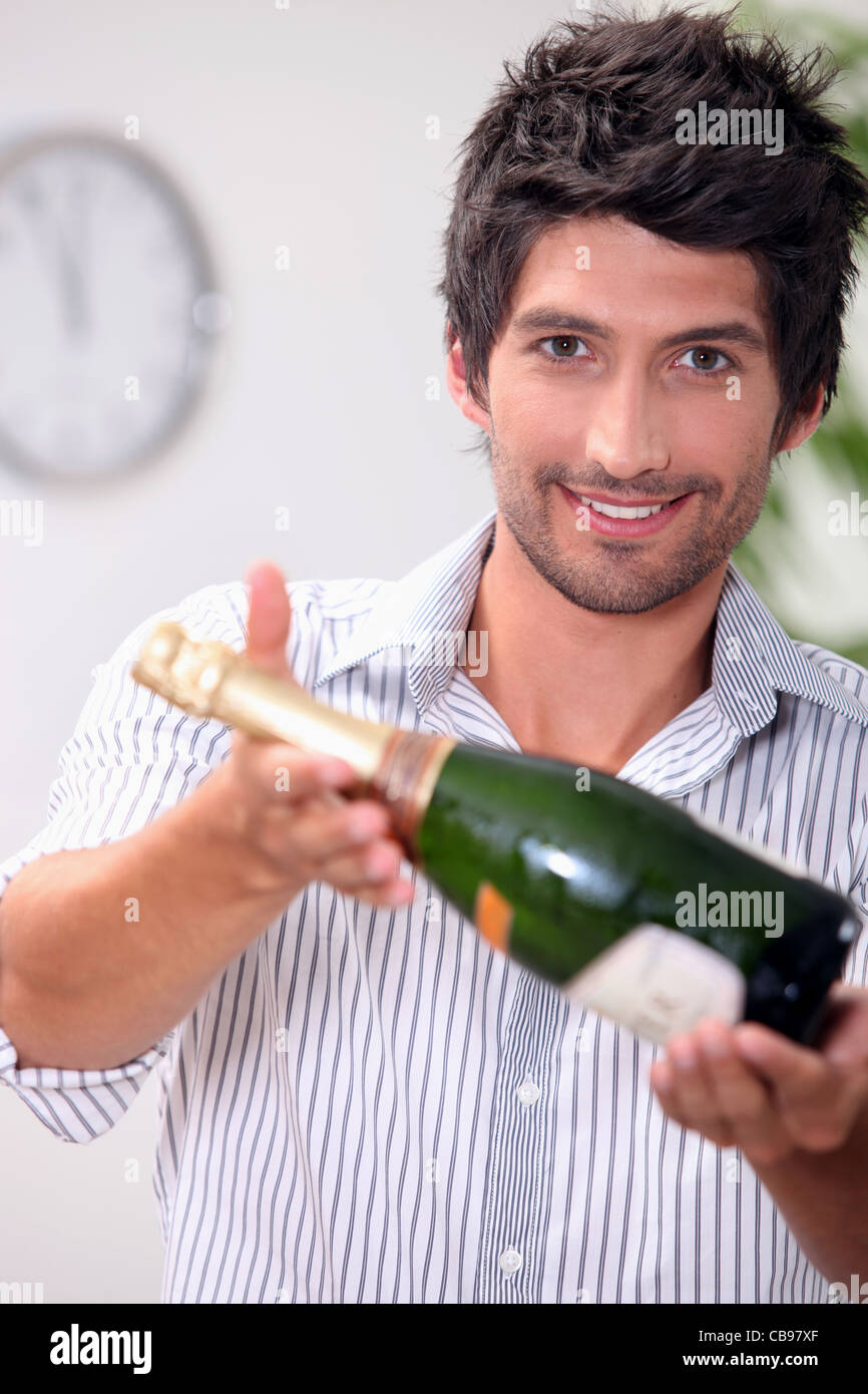 A man offering a bottle of champagne Stock Photo - Alamy