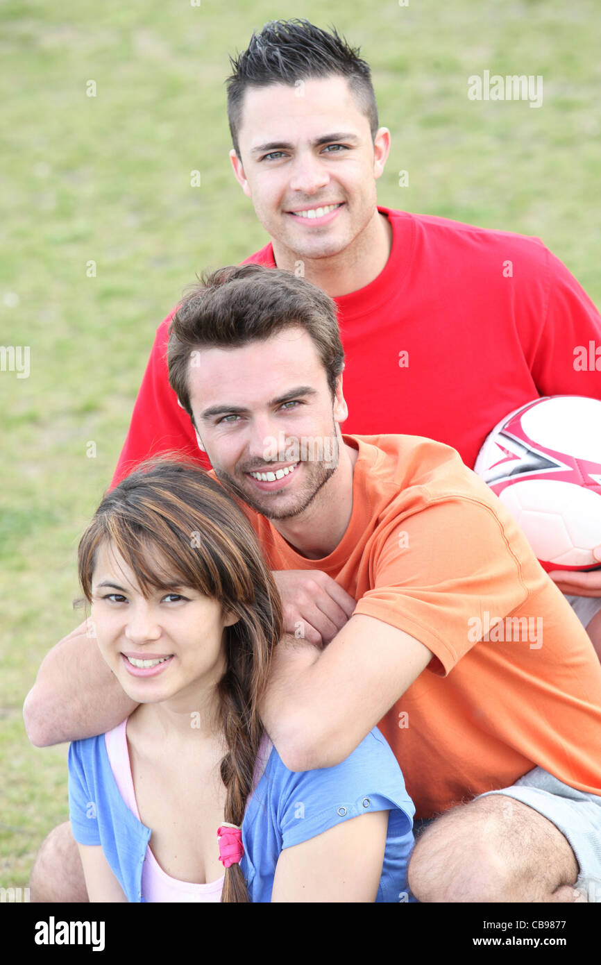 Young people playing soccer in a park Stock Photo - Alamy