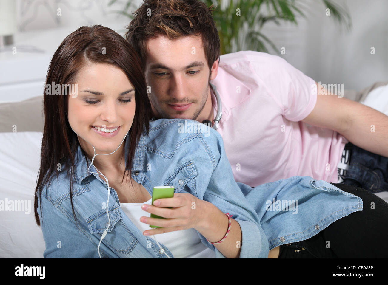 Couple listening to an mp3 player Stock Photo - Alamy