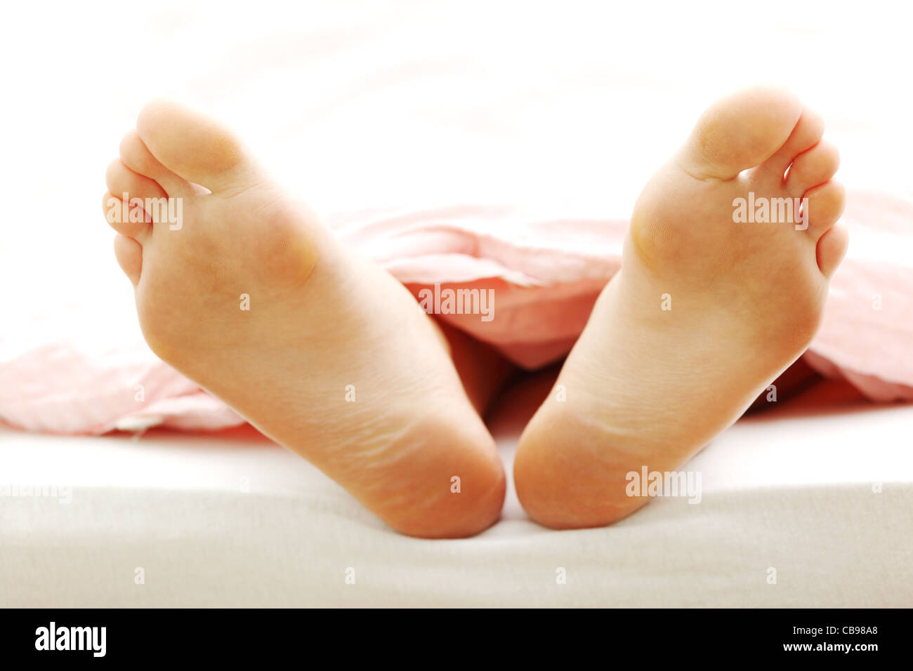 Closeup on feet sticking out fron the sheet, view on footing Stock ...