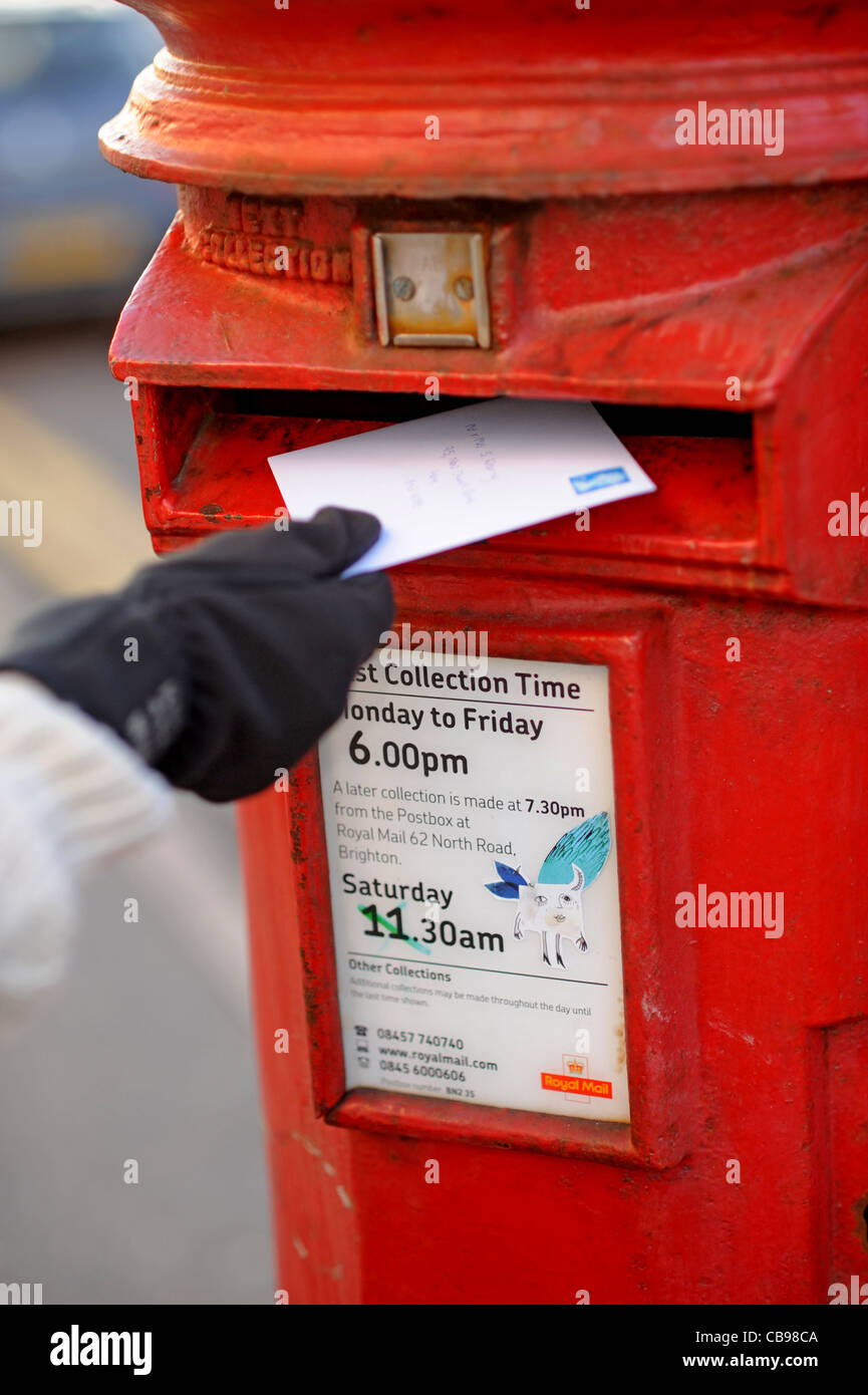 Posting a Christmas card in British red post box in time UK Stock Photo ...