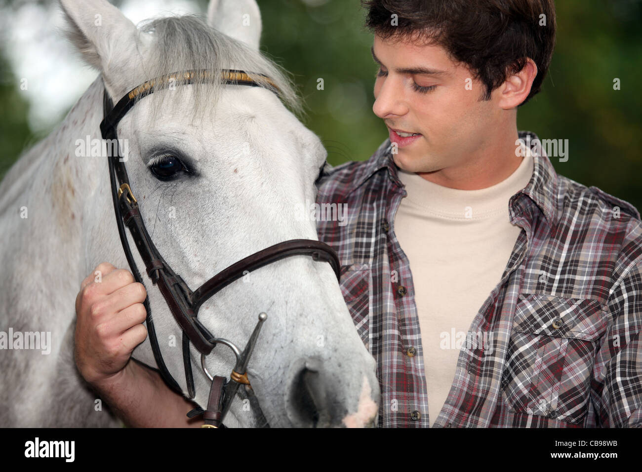 Young man with a horse Stock Photo - Alamy
