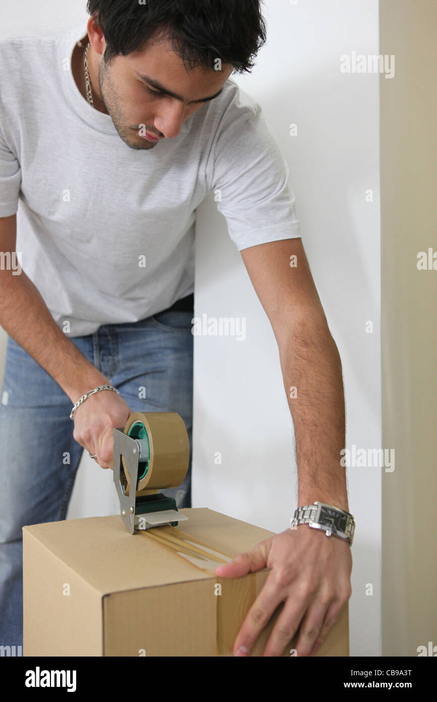 young man wrapping cardboard Stock Photo - Alamy