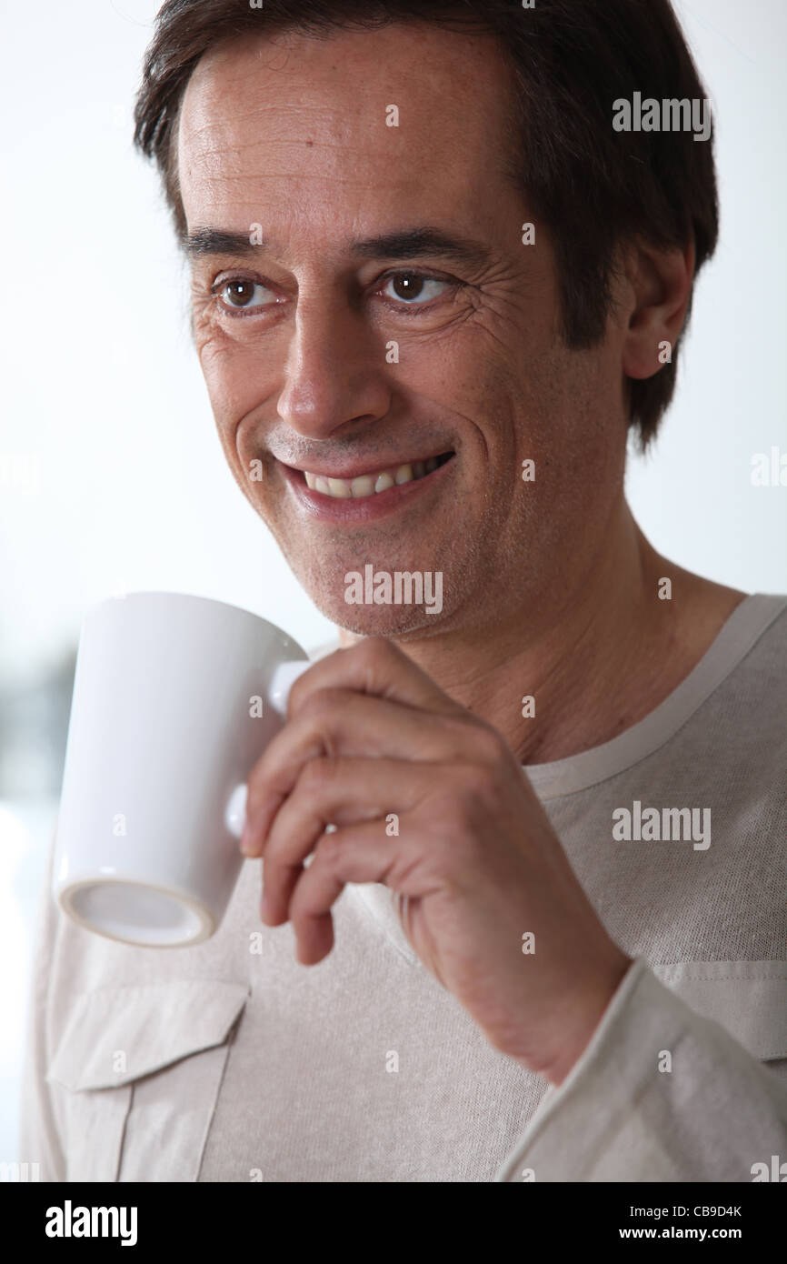 Man smiling with a cup of tea Stock Photo - Alamy