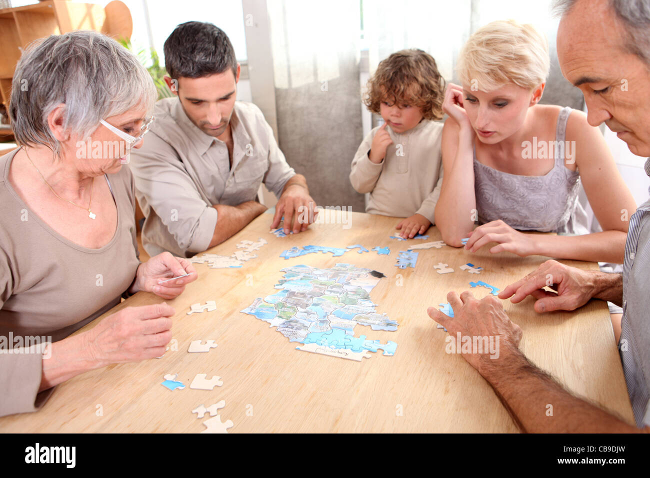 Family making puzzle Stock Photo - Alamy