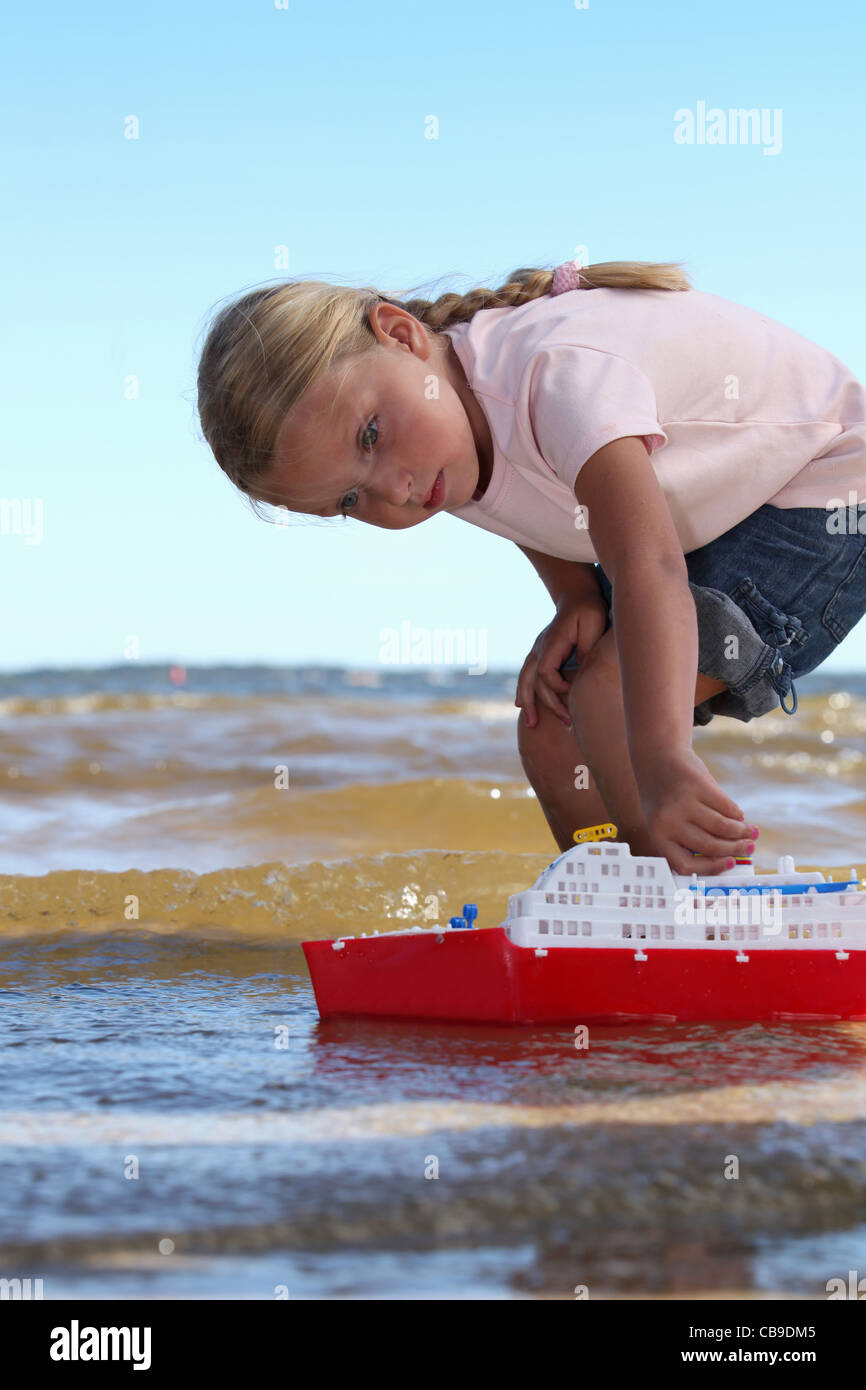 Girl playing with boat Stock Photo - Alamy