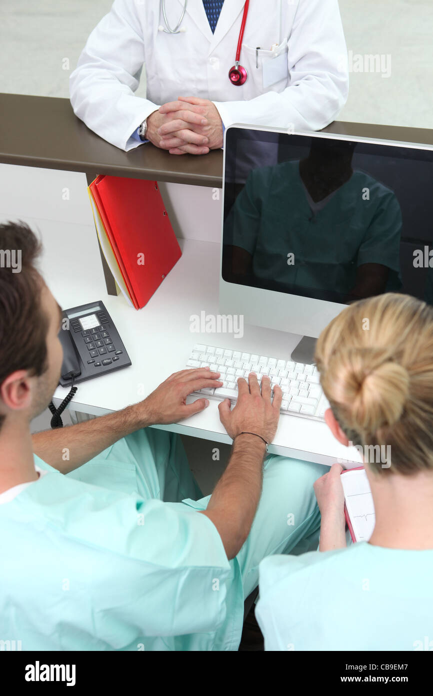 Medical assistant looking at his reflection on a computer screen Stock ...
