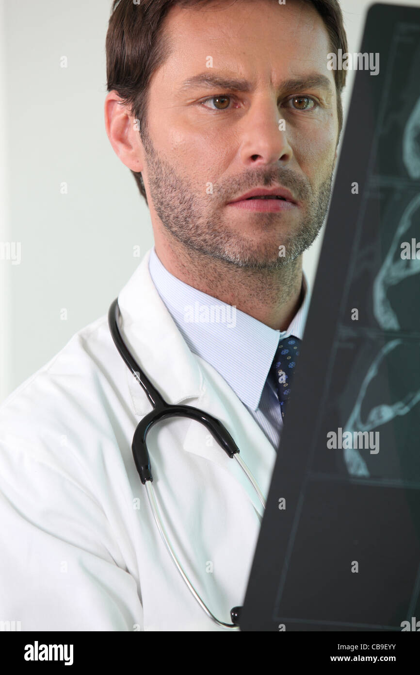 A worried doctor examining medical radios Stock Photo - Alamy