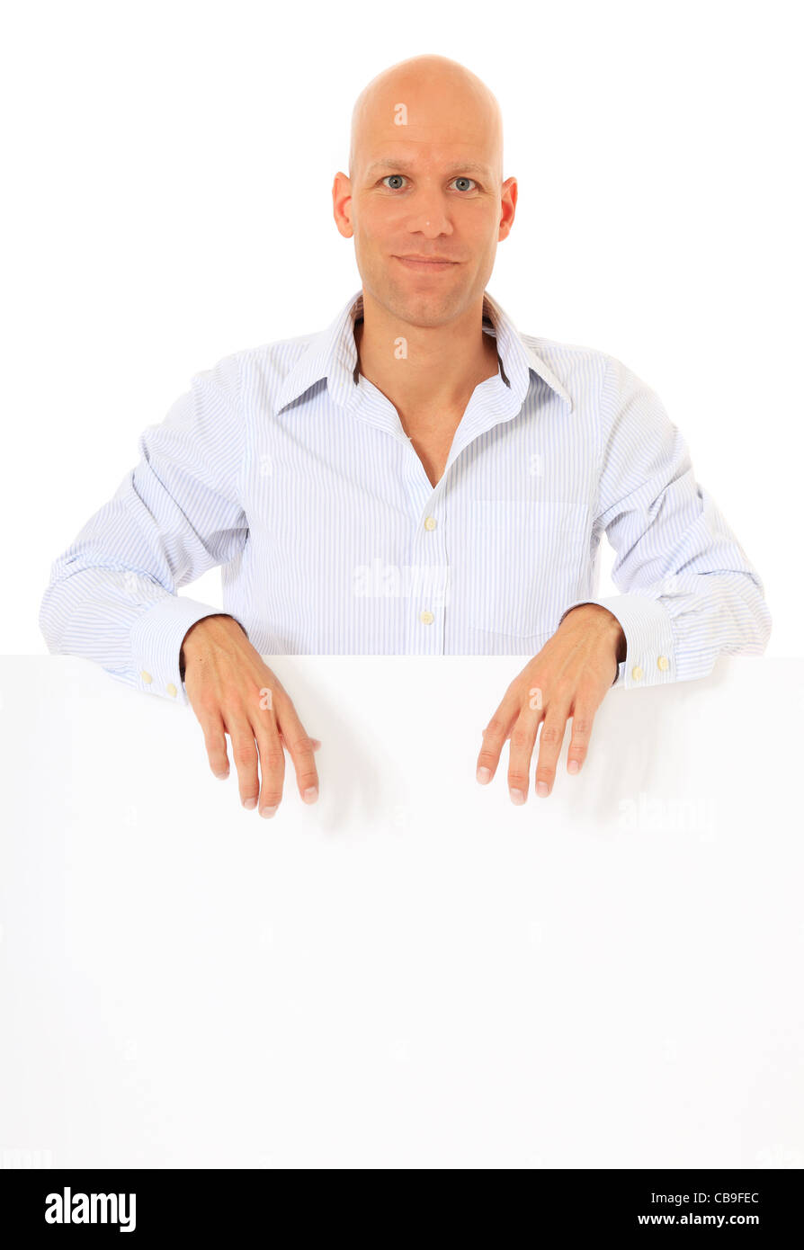 Attractive young man standing behind white wall. All on white ...