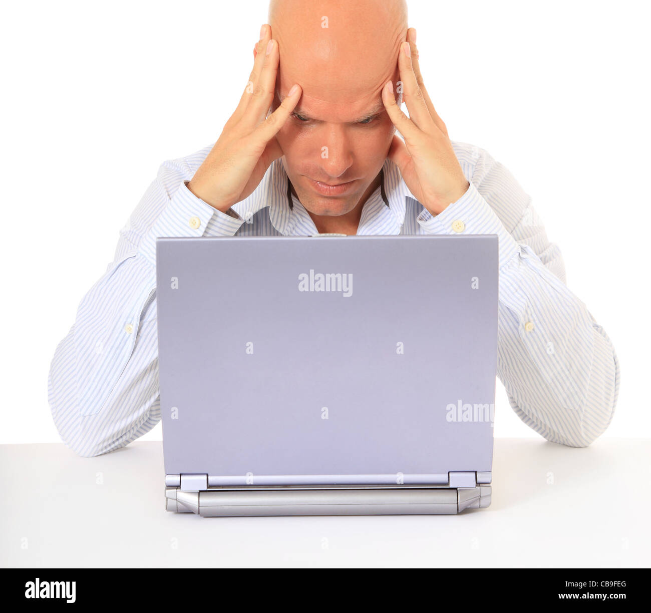 Frustrated man sitting in front of his laptop. All on white background ...