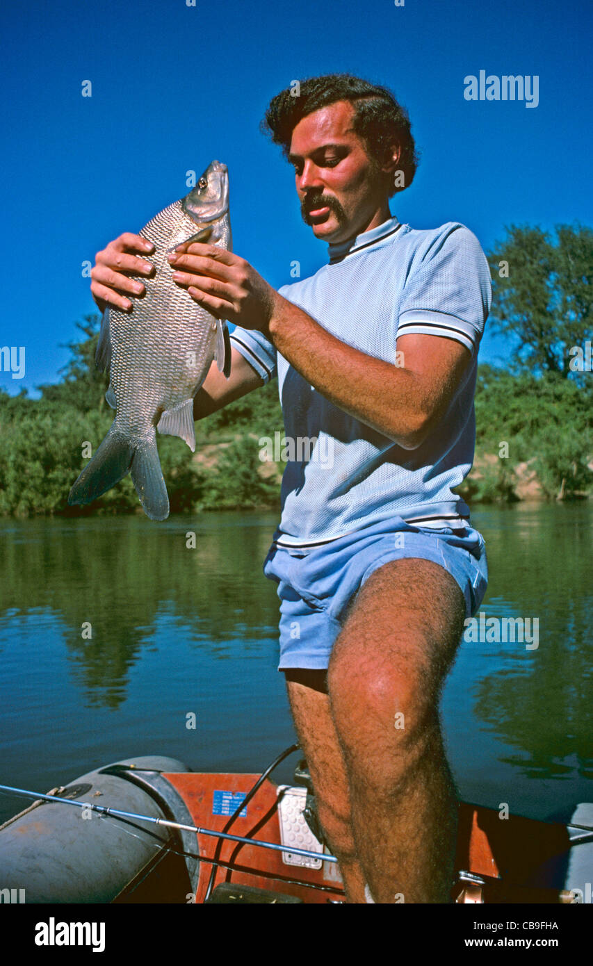 Fisherman on an African river with a fish known locally as 'Chessa ...