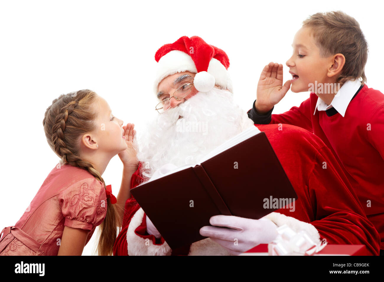 Image of Santa listening to little boy and girl whispering their wishes ...