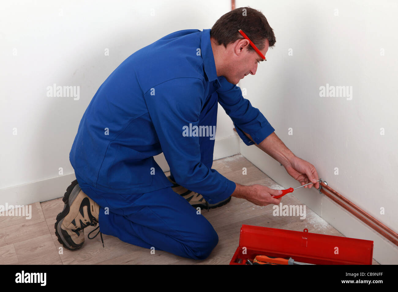 Plumber fixing copper pipe Stock Photo - Alamy