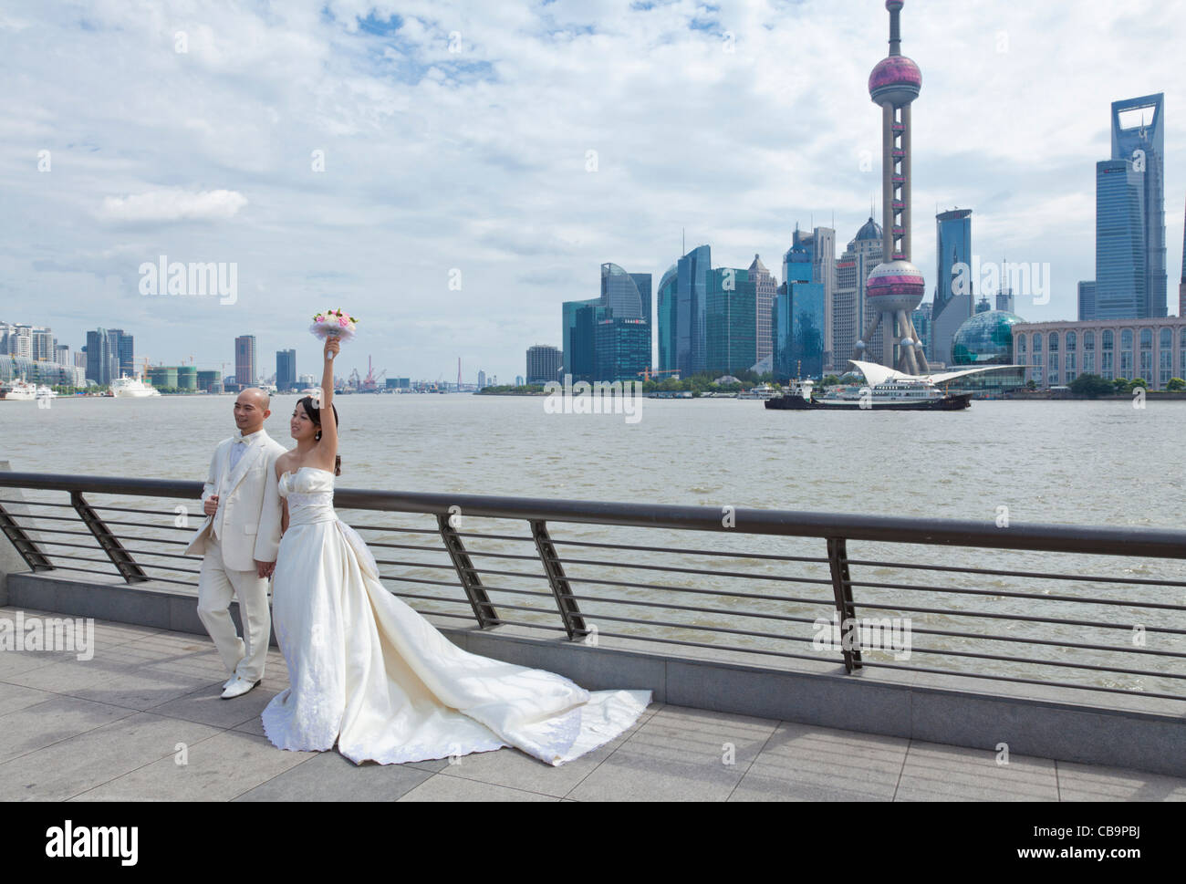 Chinese wedding bride and groom on the Bund waterfront posing in front ...