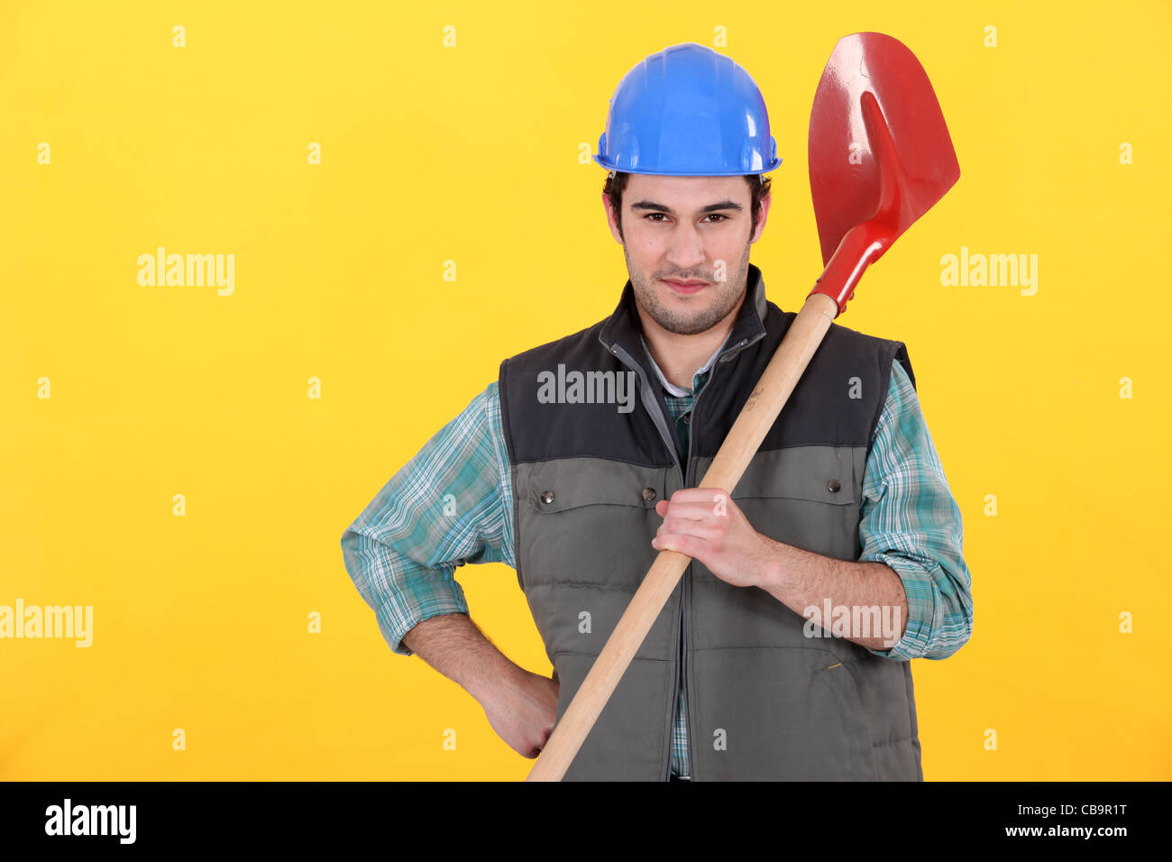 Builder stood with spade Stock Photo - Alamy