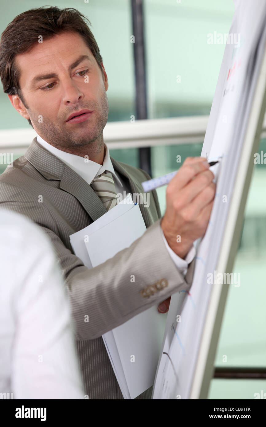 Male executive writing on a full size flipchart Stock Photo - Alamy