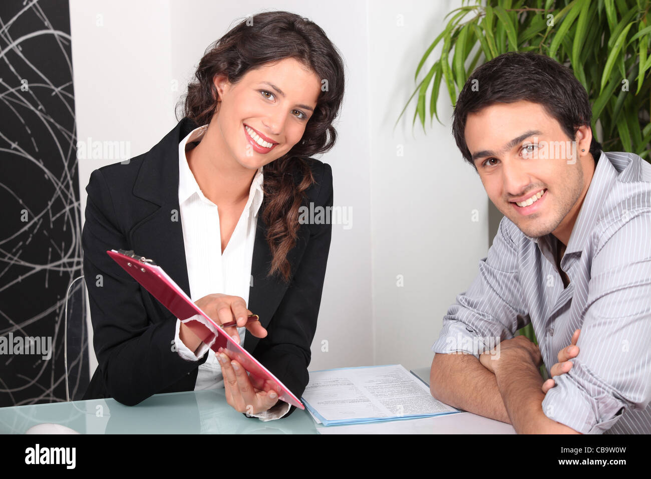 Woman showing man where to sign Stock Photo - Alamy