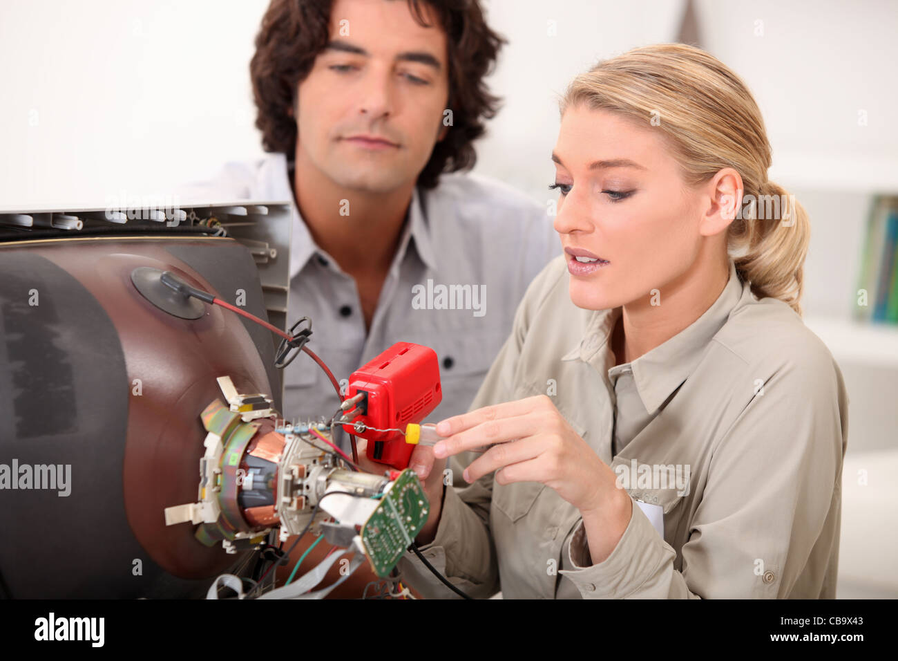 Couple fixing television Stock Photo - Alamy