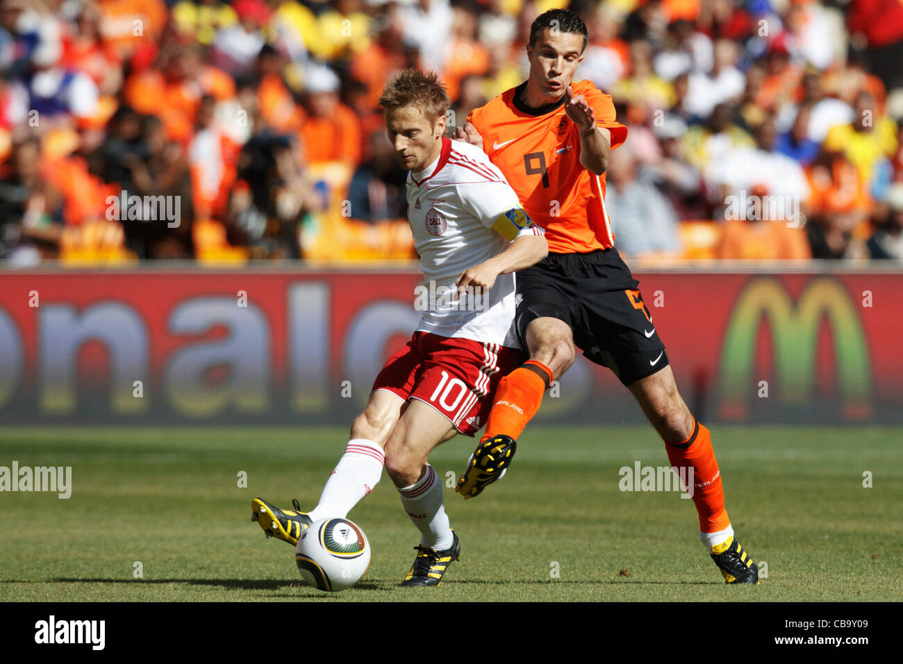 Robin van Persie of the Netherlands (R) pressures Denmark team captain ...