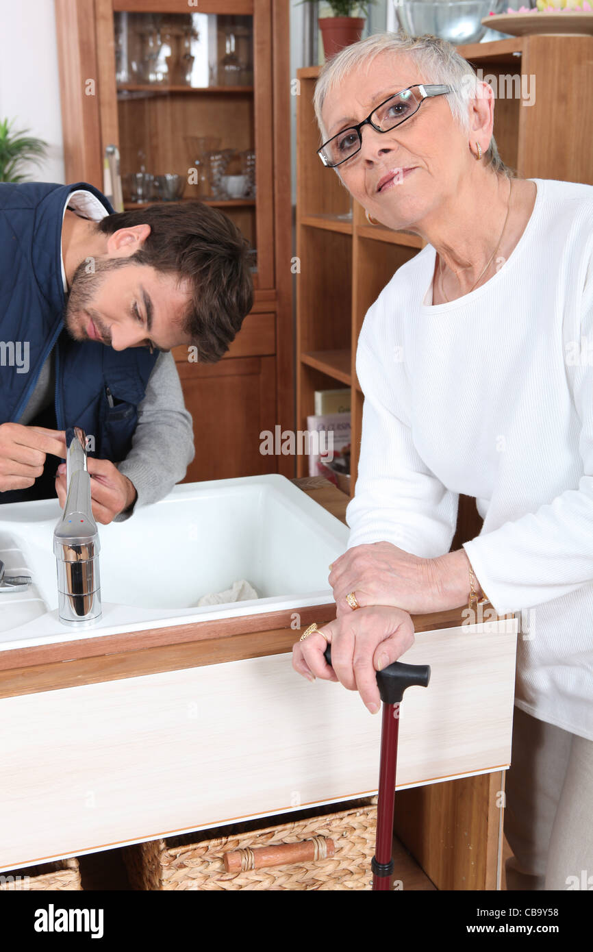 Son fixing tap Stock Photo - Alamy