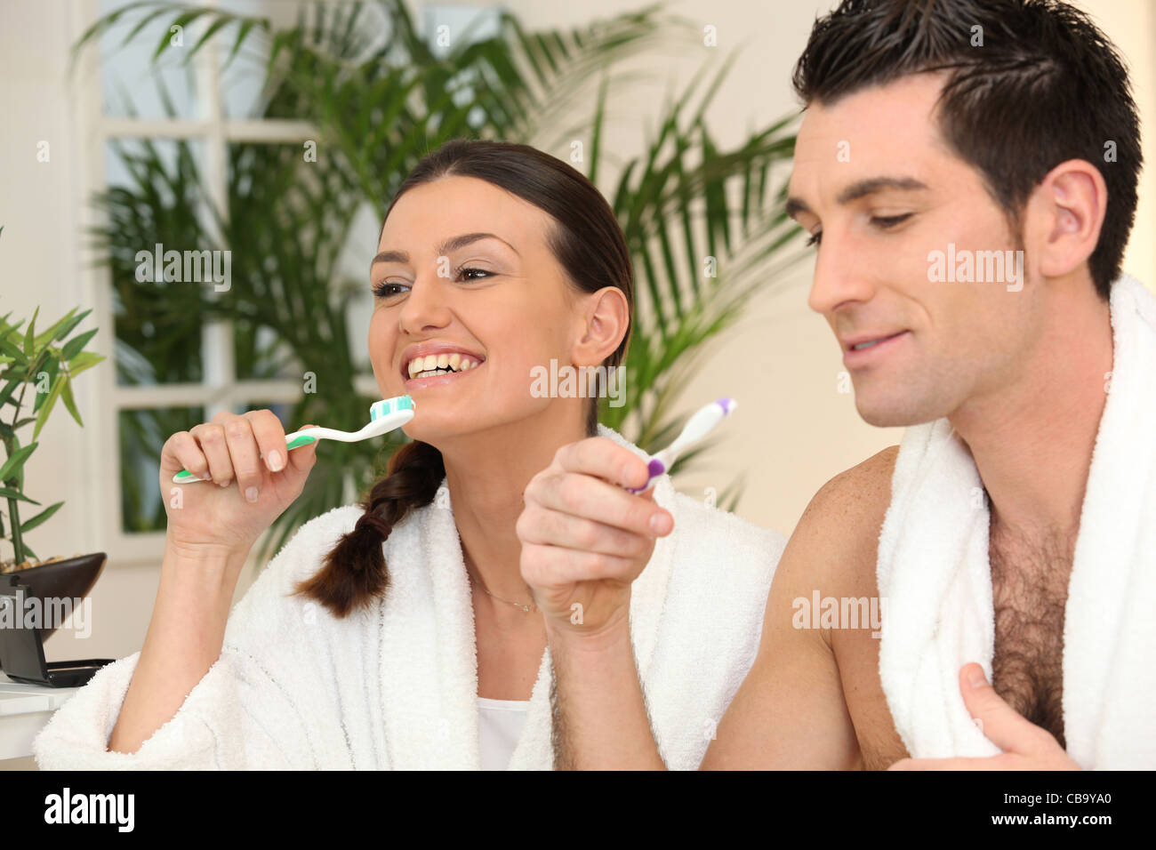 Couple brushing teeth in bathroom Stock Photo - Alamy
