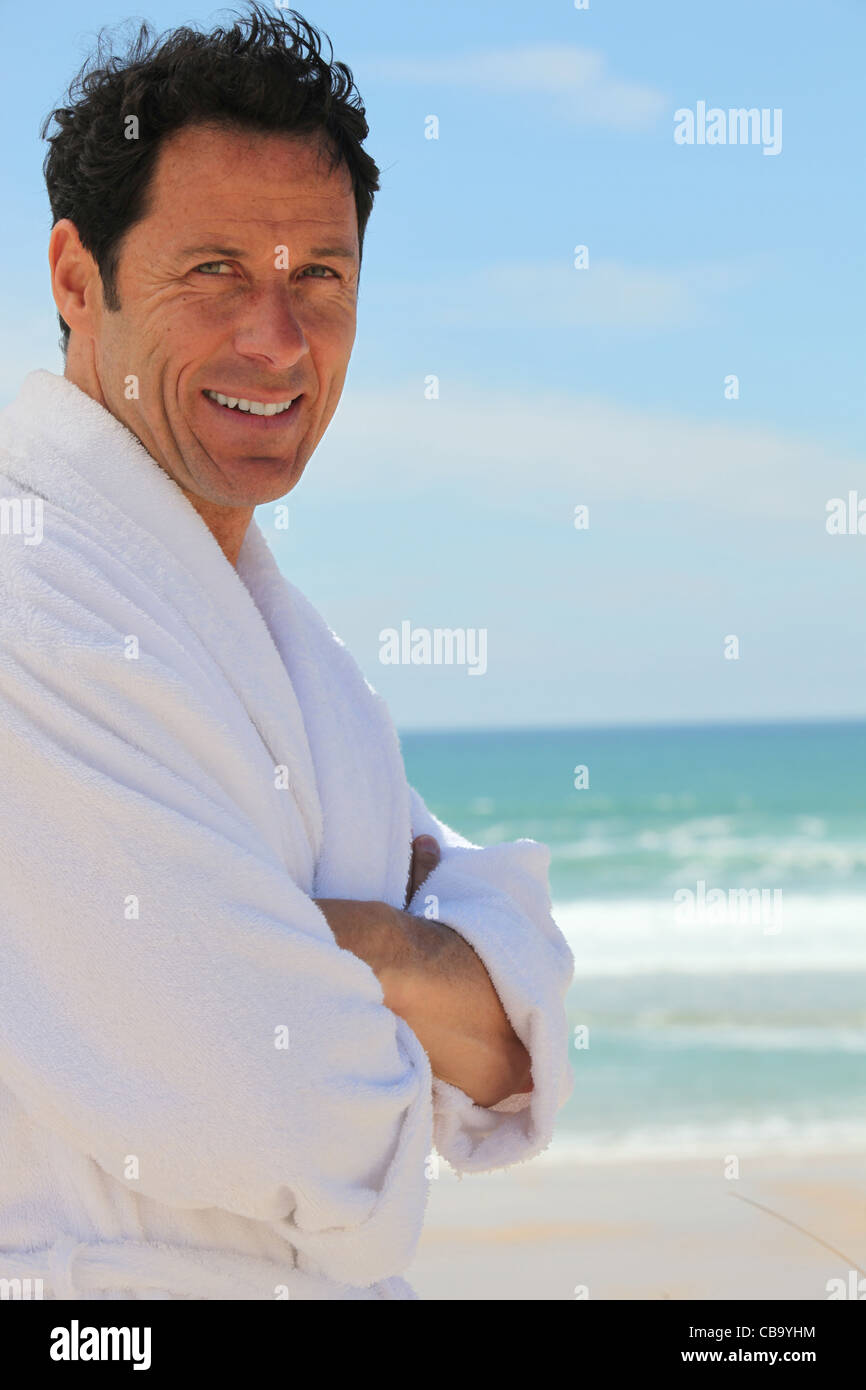 Man n dressing gown stood on beach Stock Photo - Alamy