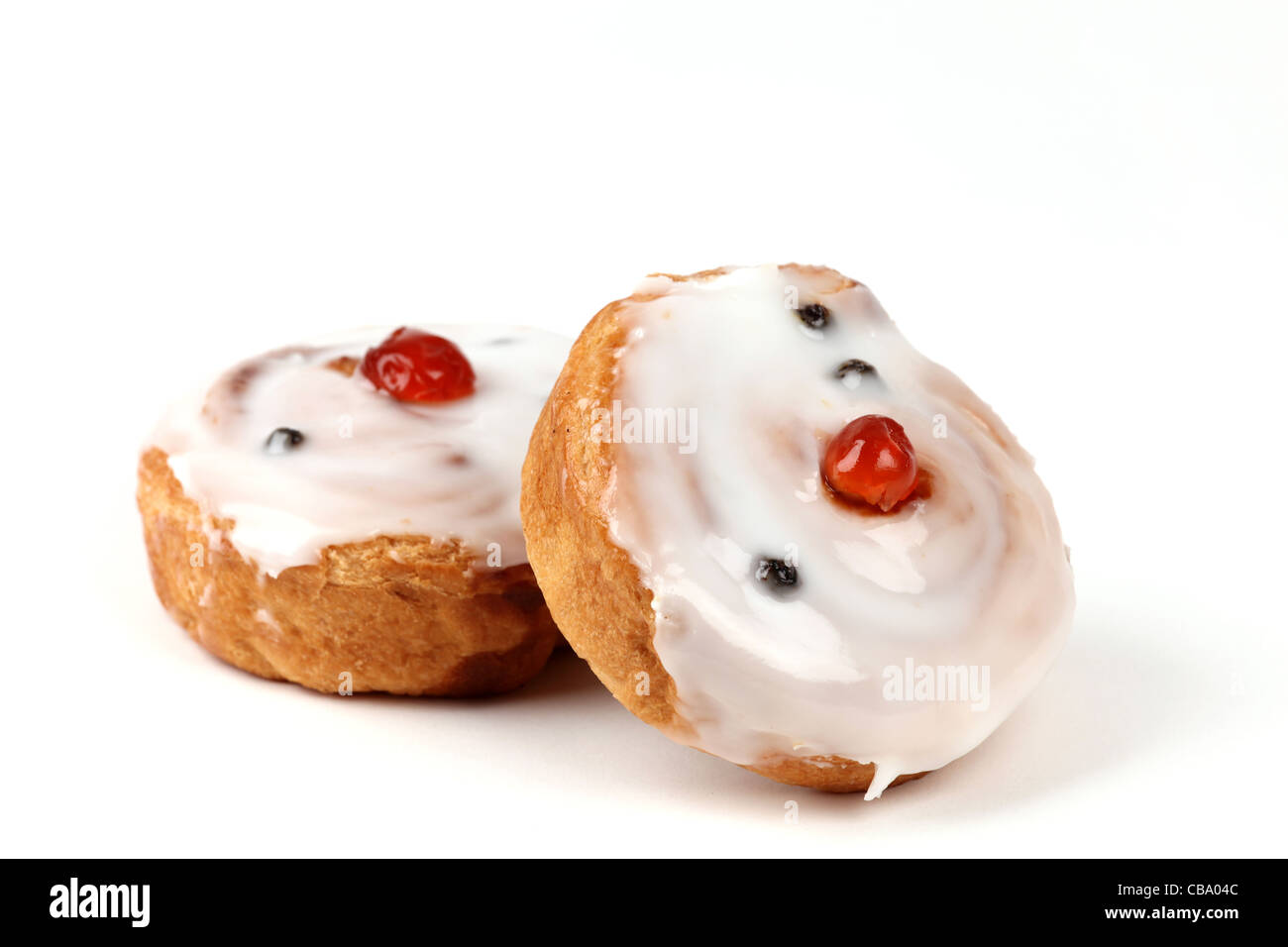 Two fresh iced Belgian buns on a white background with selective focus ...