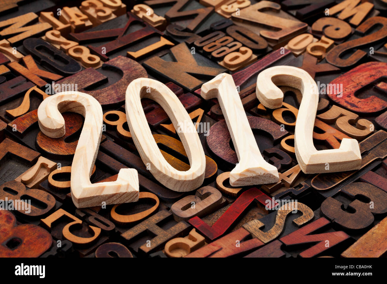 year of 2012 - wooden unfinished numbers against background of random ...