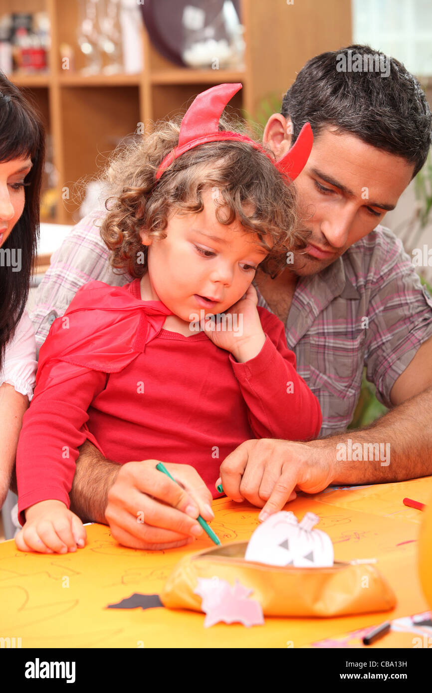 Parents helping child with Halloween decorations Stock Photo - Alamy