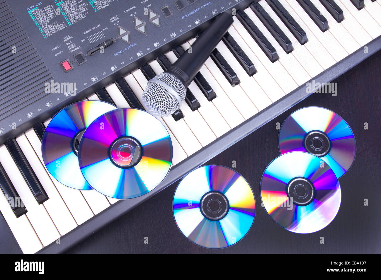 Vocal microphone, cd discs and electronic keyboard, Closeup on black ...