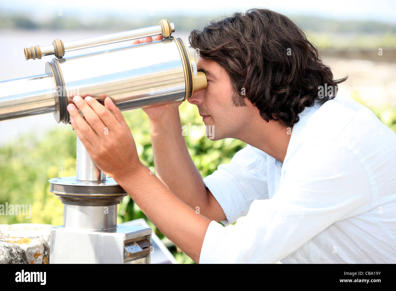 Man looking through a telescope Stock Photo - Alamy
