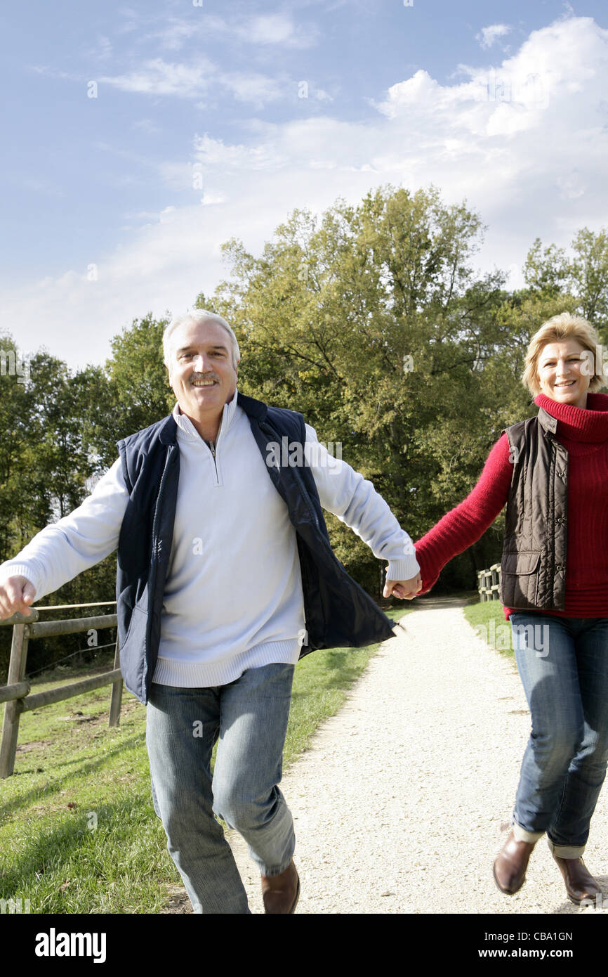 Couple walking hand in hand Stock Photo - Alamy