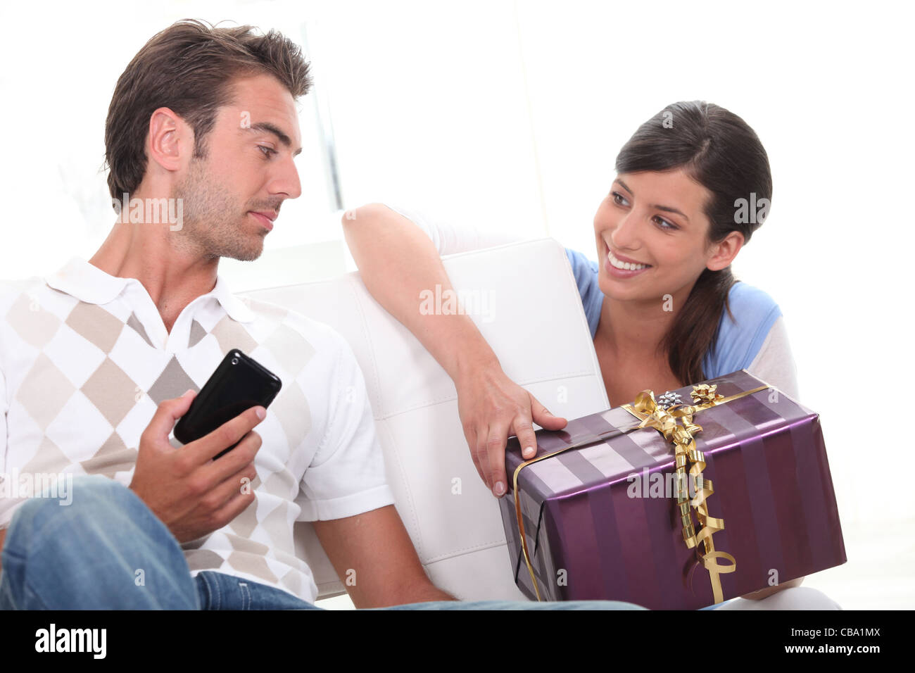 Woman offering gift to boyfriend Stock Photo - Alamy