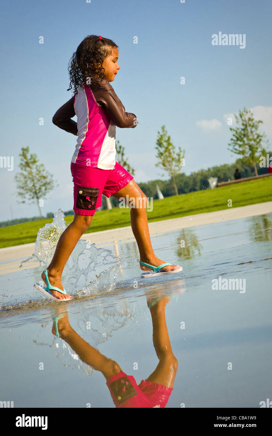 Young mixed race girl running through water in a splash park Stock ...
