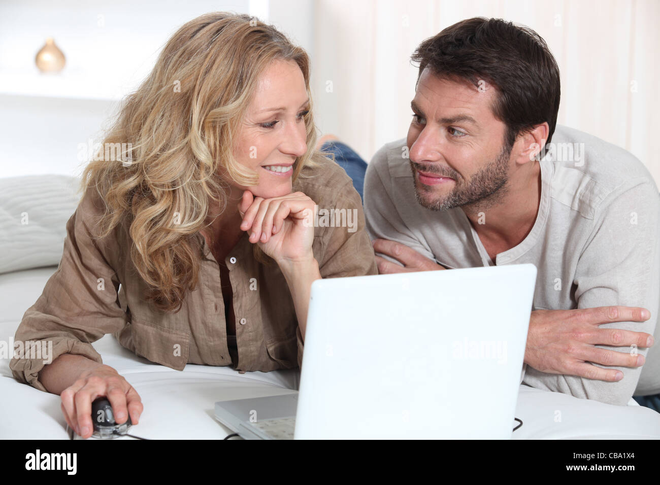 Couple on laptop looking into each other's eyes Stock Photo - Alamy