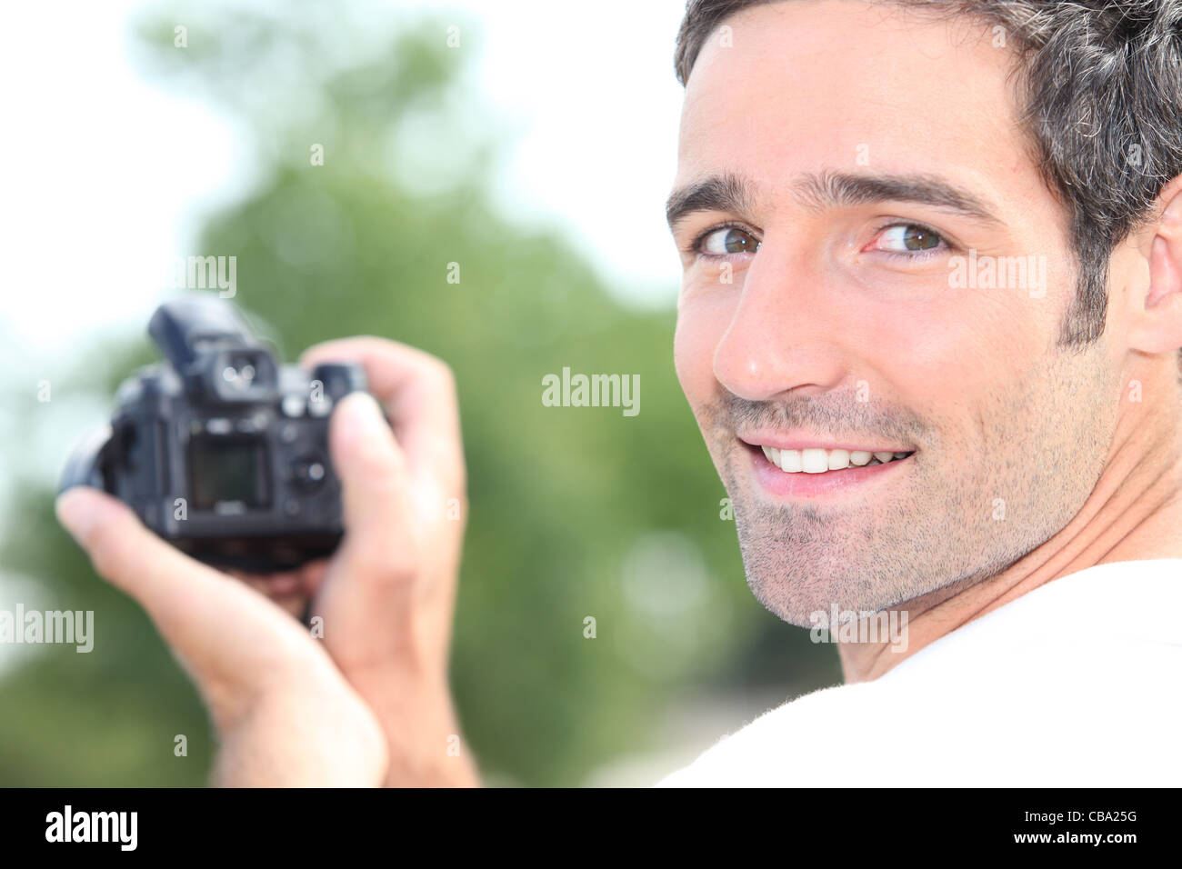 Man looking at the back of a digital camera Stock Photo - Alamy