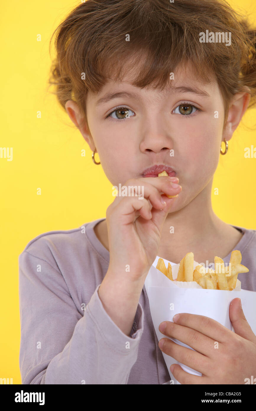 Little girl eating French fries Stock Photo - Alamy