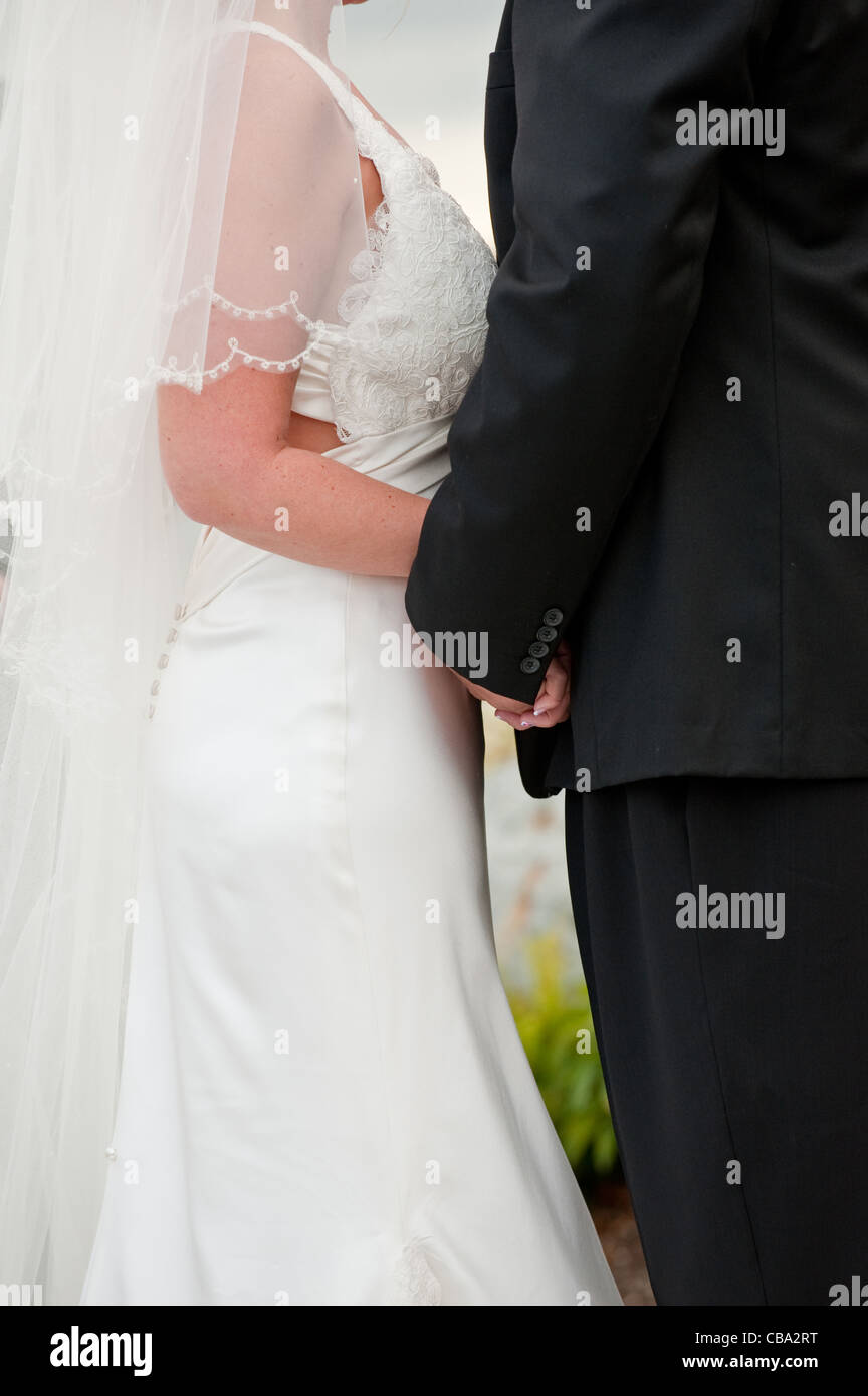 Bride and groom holding hands during wedding ceremony Stock Photo - Alamy