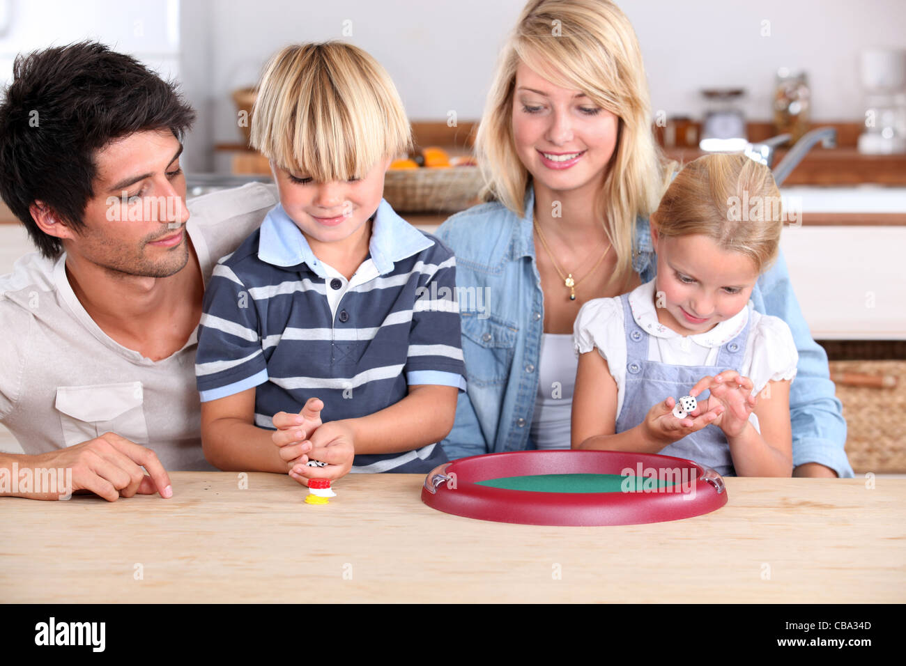 Young family playing dice Stock Photo - Alamy