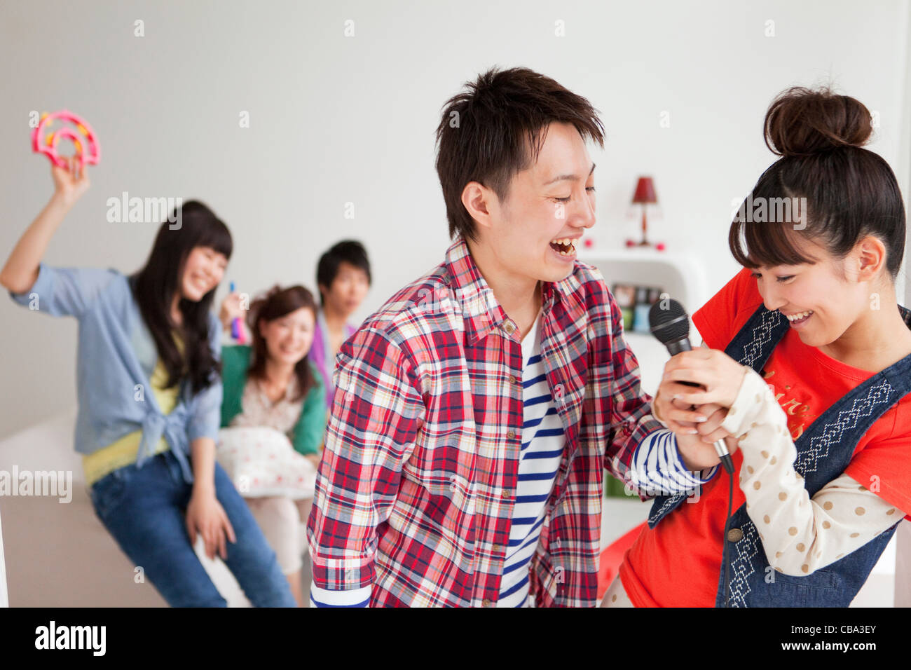 Young people fighting over microphone Stock Photo - Alamy