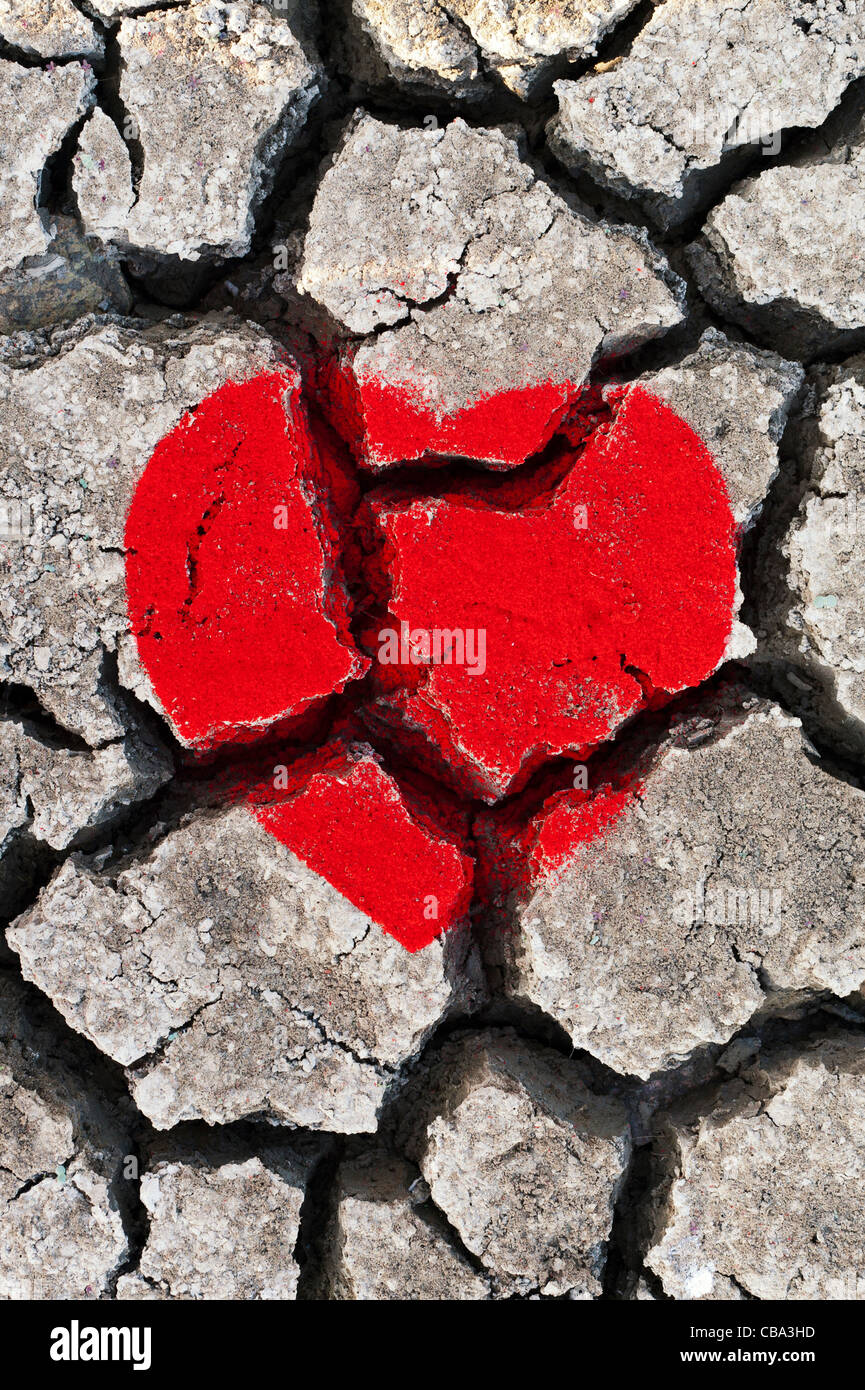 Broken Heart Concept. Heart shape with red coloured powder on dry ...