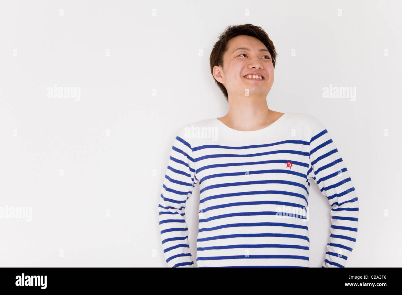 Young man looking away and smiling Stock Photo - Alamy