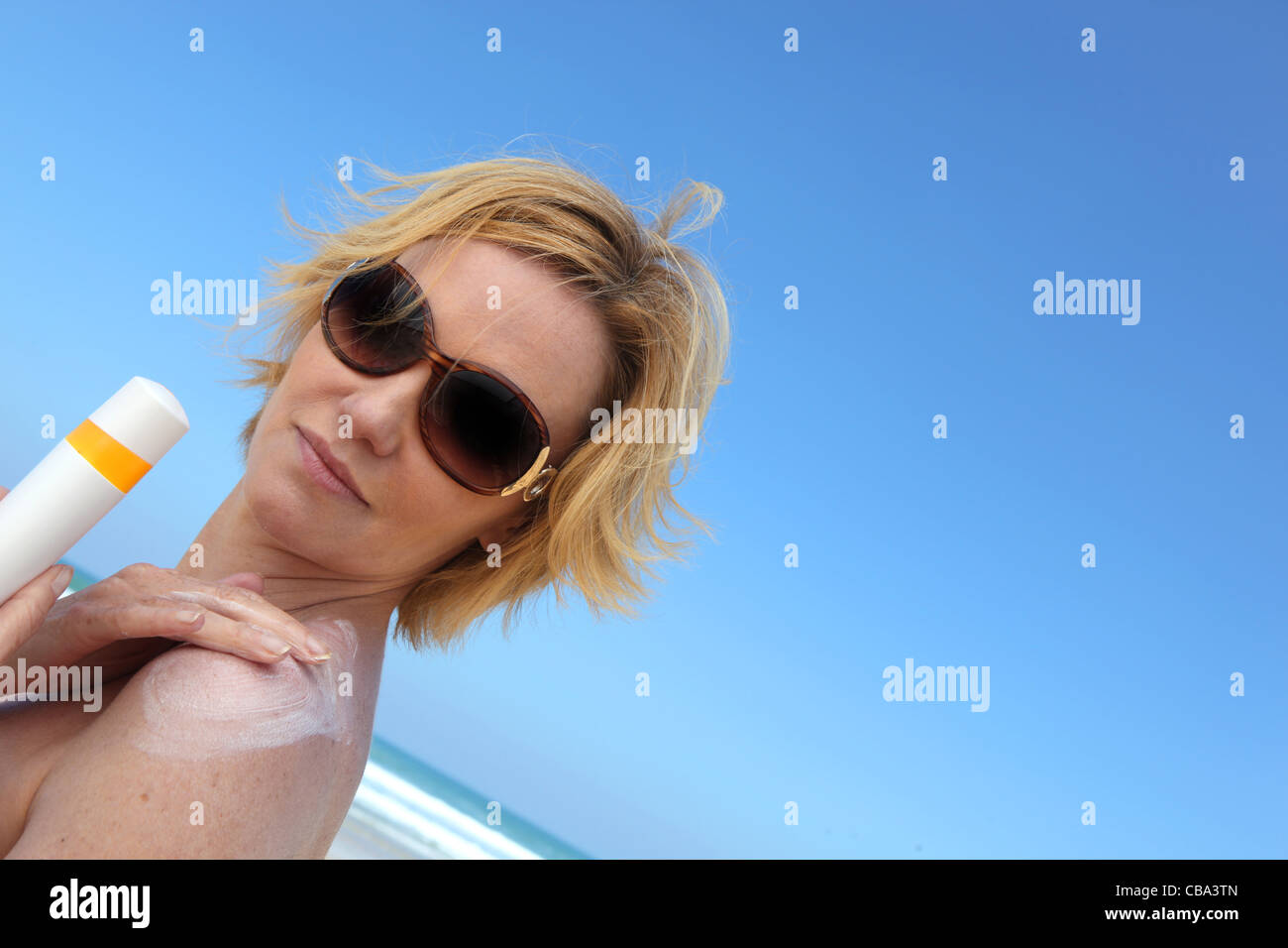 Woman applying sun cream to her shoulder Stock Photo - Alamy