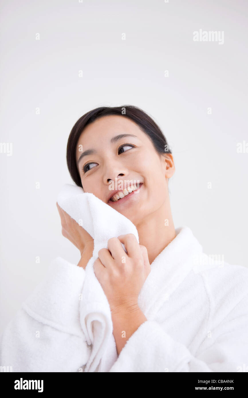 Woman wiping face with towel Stock Photo - Alamy